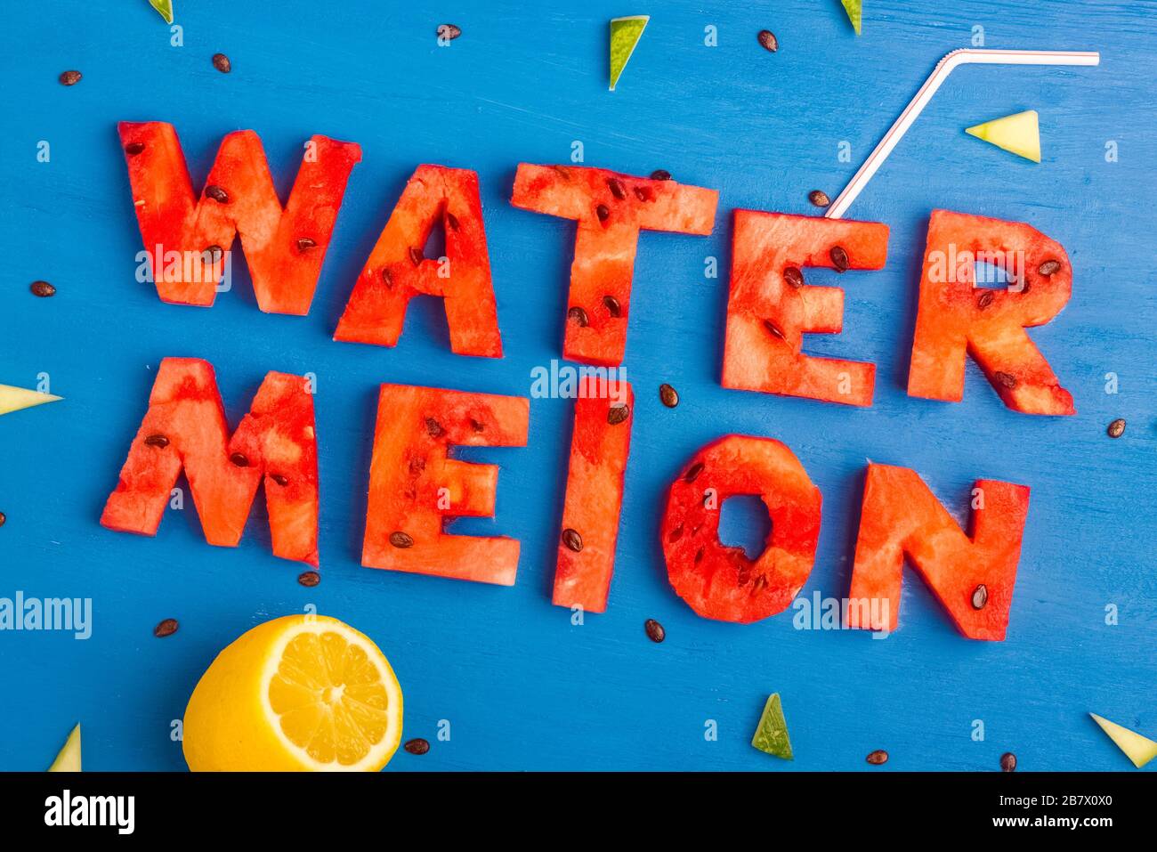 Word watermelon from pieces of watermelon with bones and lemon. On a ...