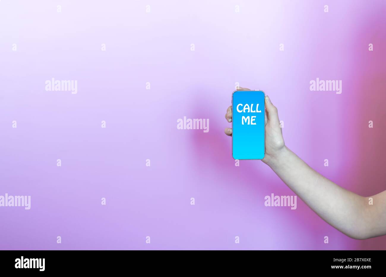 young womans arm & hand holding smartphone with call me written on the ...