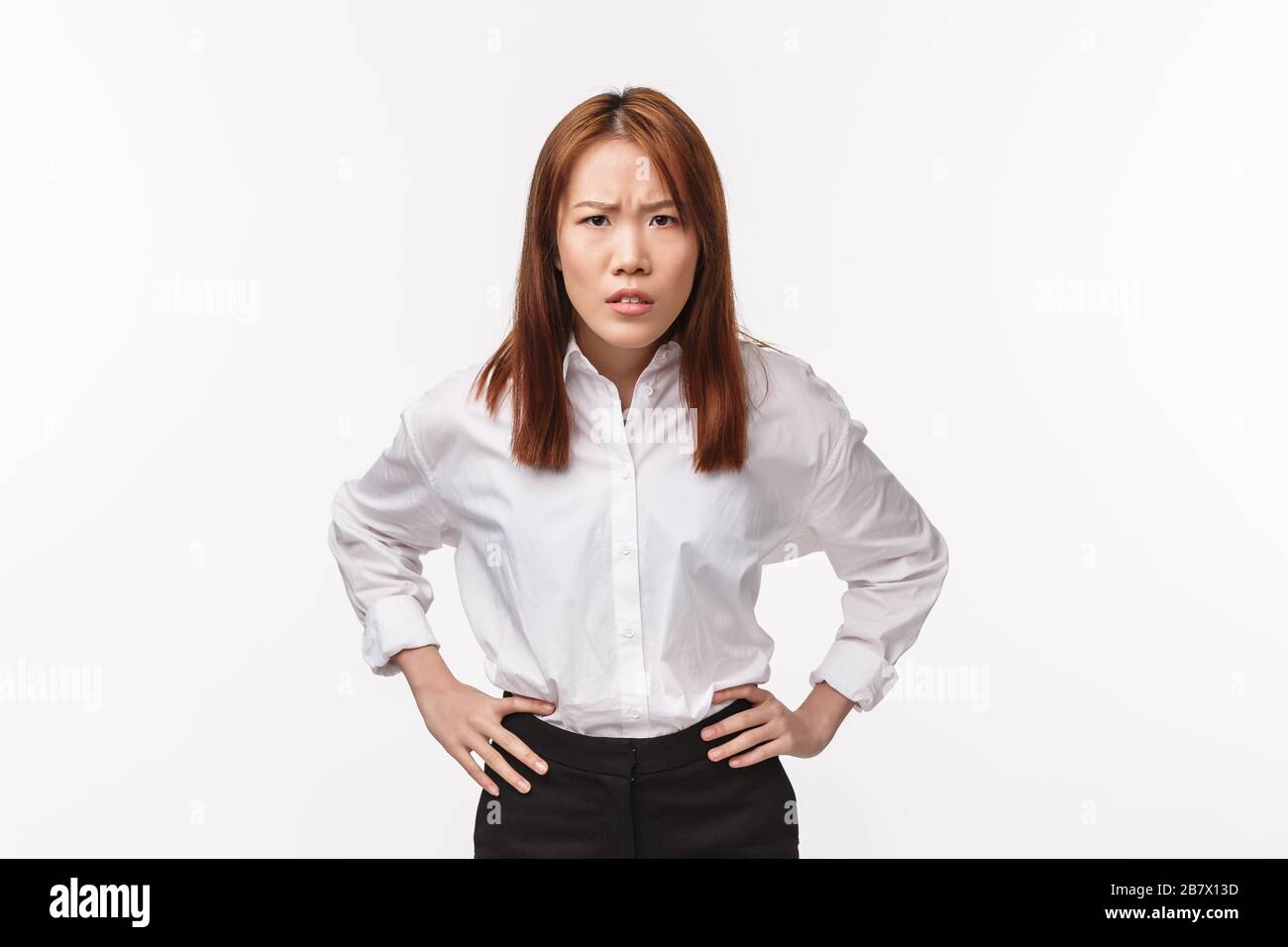 Portrait of disappointed and strict asian woman hold hands on waist and ...