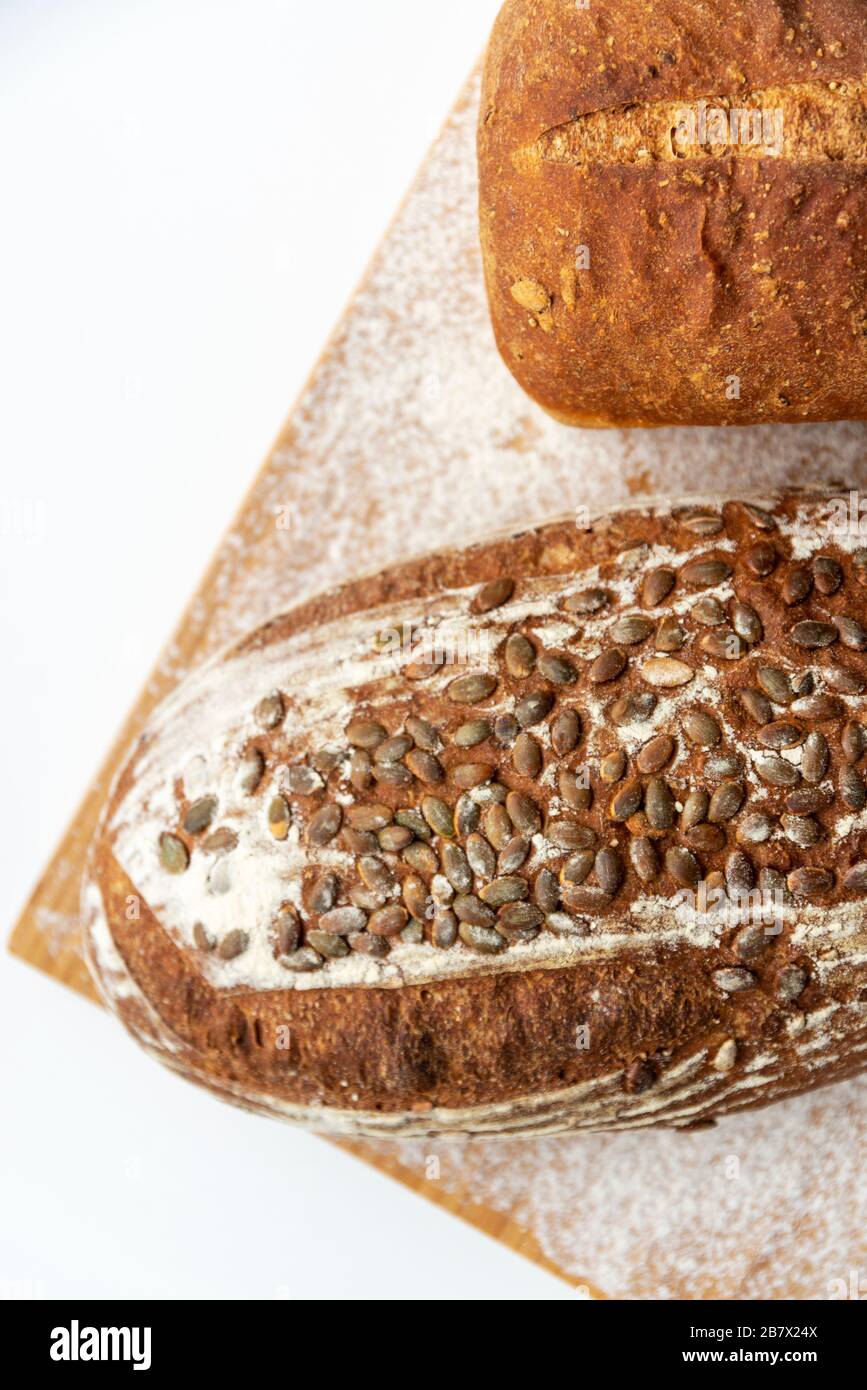 2 loaves of freshly baked multi-grain bread, shot from above on a ...