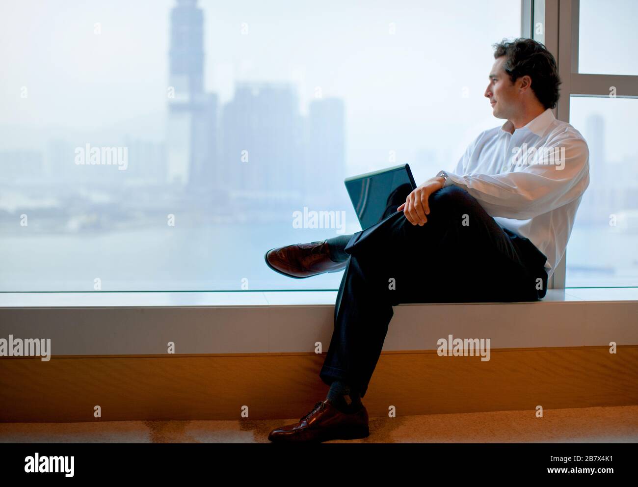 Man sitting on window ledge hi-res stock photography and images - Alamy
