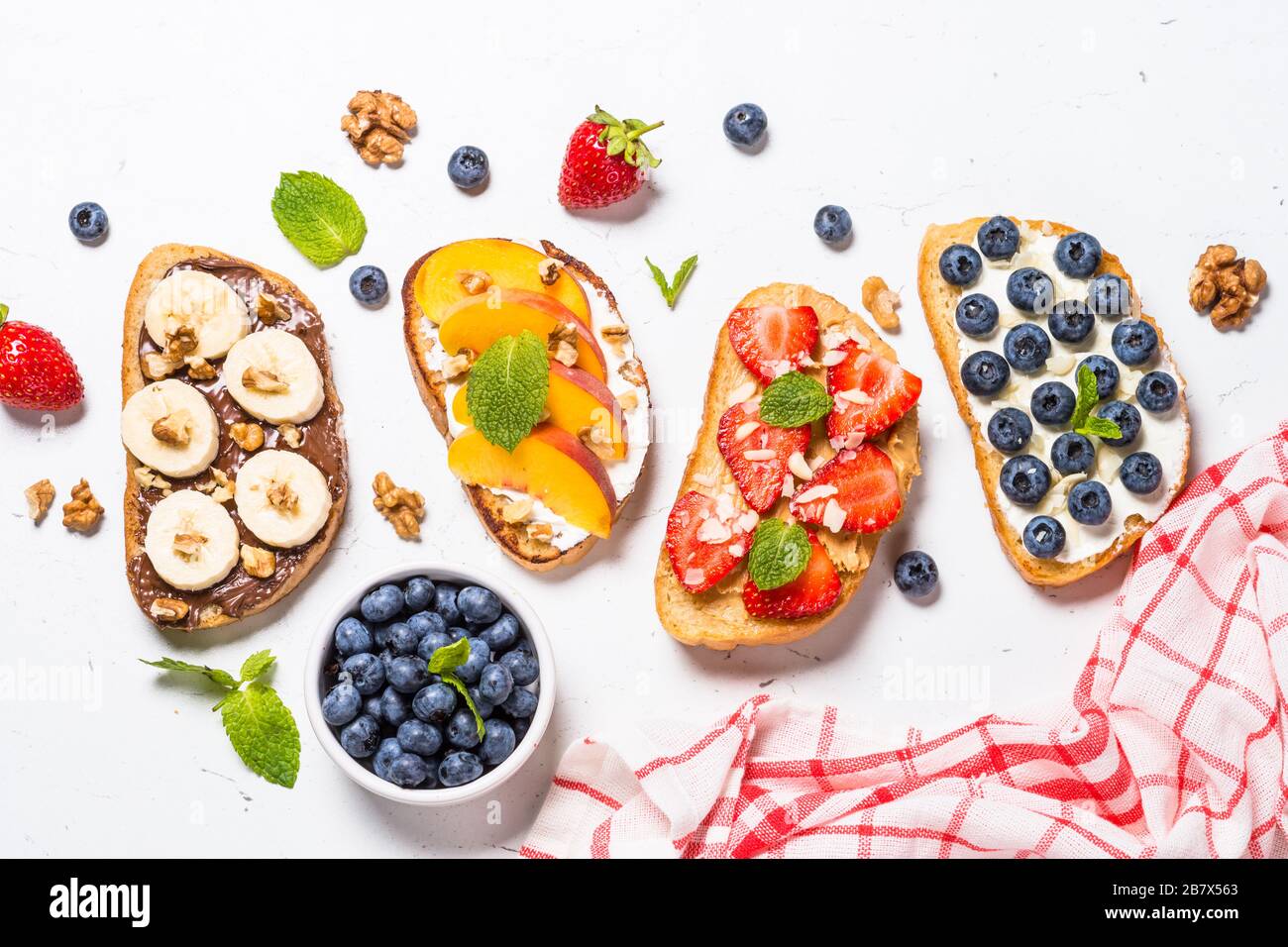 Sweet toast assortment with fresh fruit and berries on white Stock ...