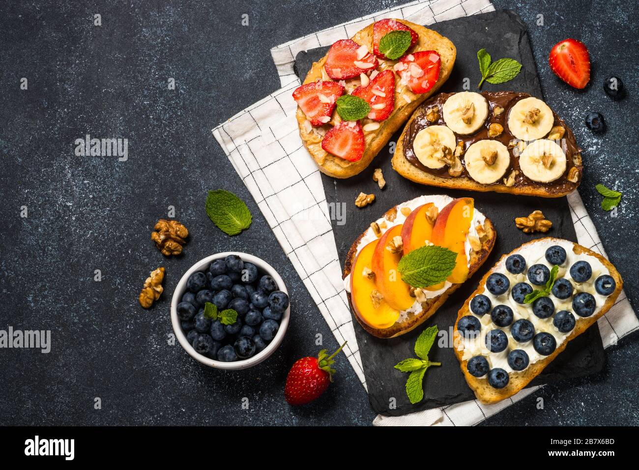 Sweet toast assortment with fresh fruit and berries on black Stock ...