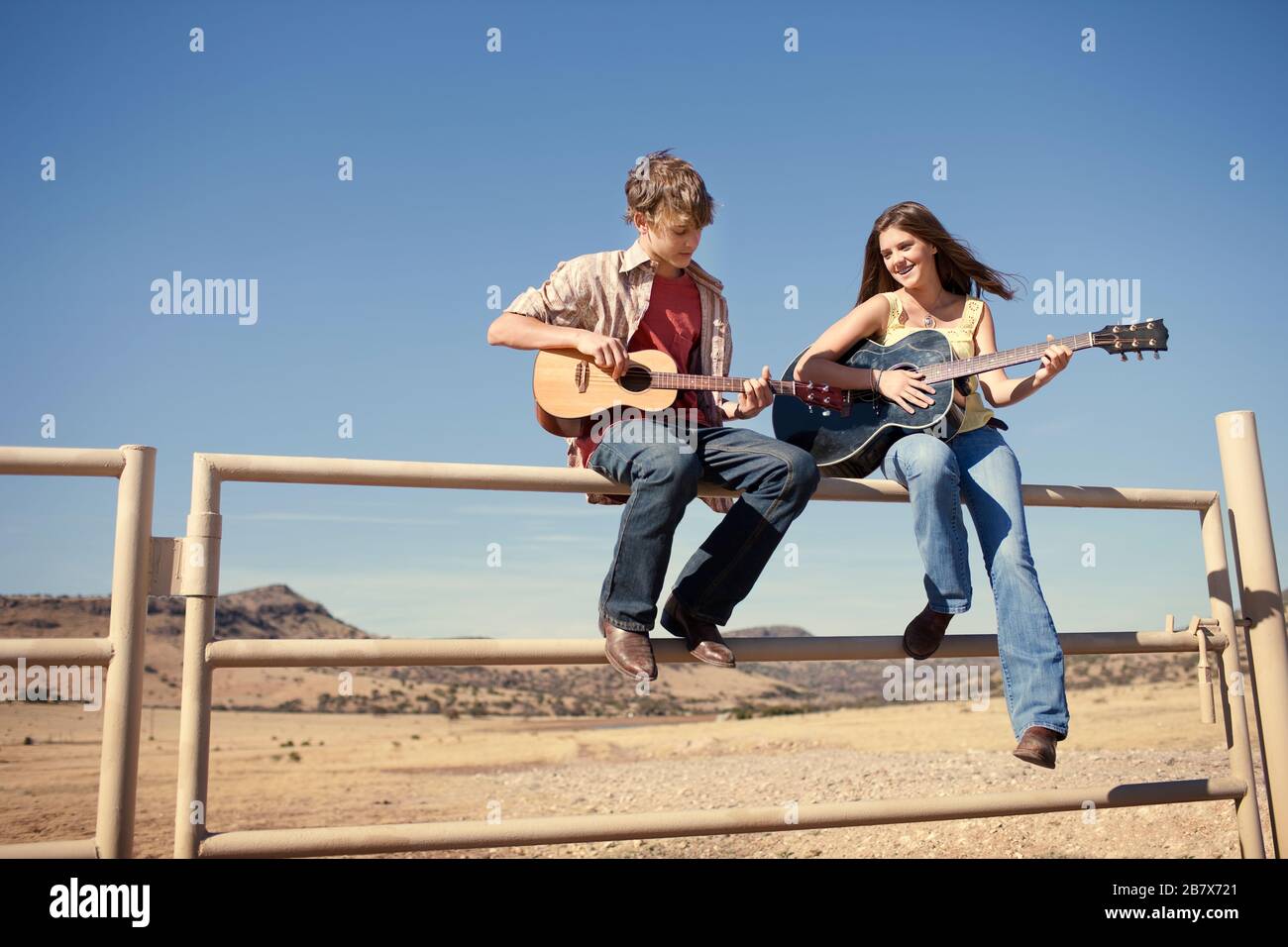 Two smiling teenagers playing acoustic guitars Stock Photo - Alamy