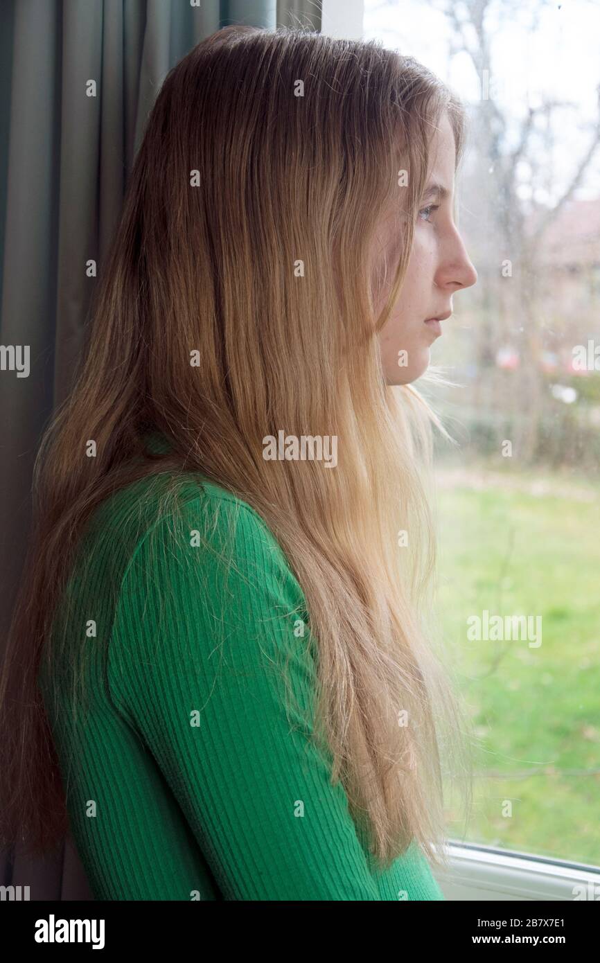 Sad teenage girl stares out of window Stock Photo - Alamy