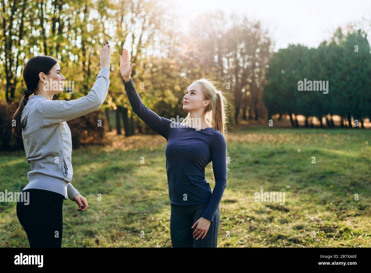 Two girls in the park are exercising and clapping their hands Stock ...