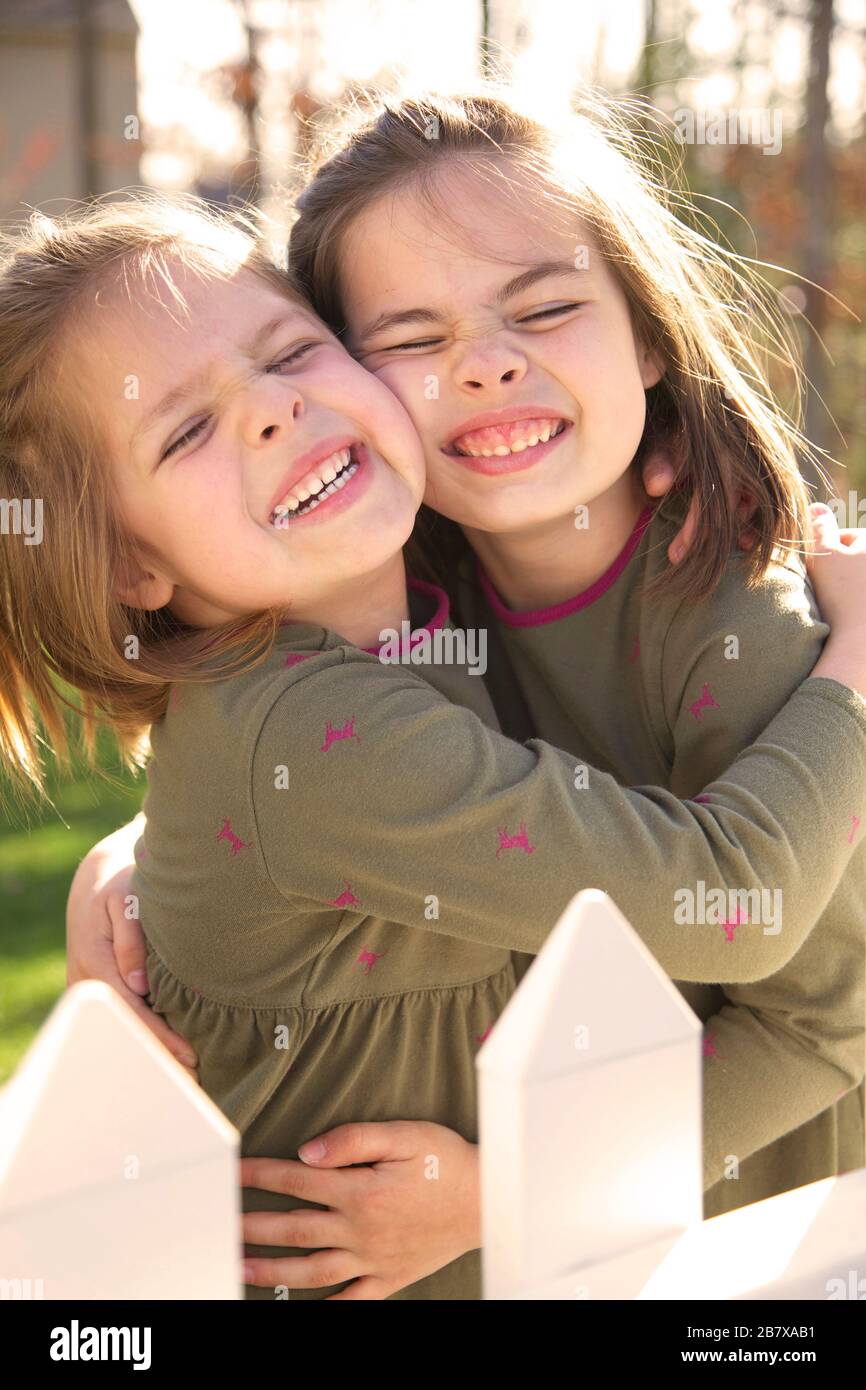 Sisters Hugging in the Sun Smiling Stock Photo - Alamy