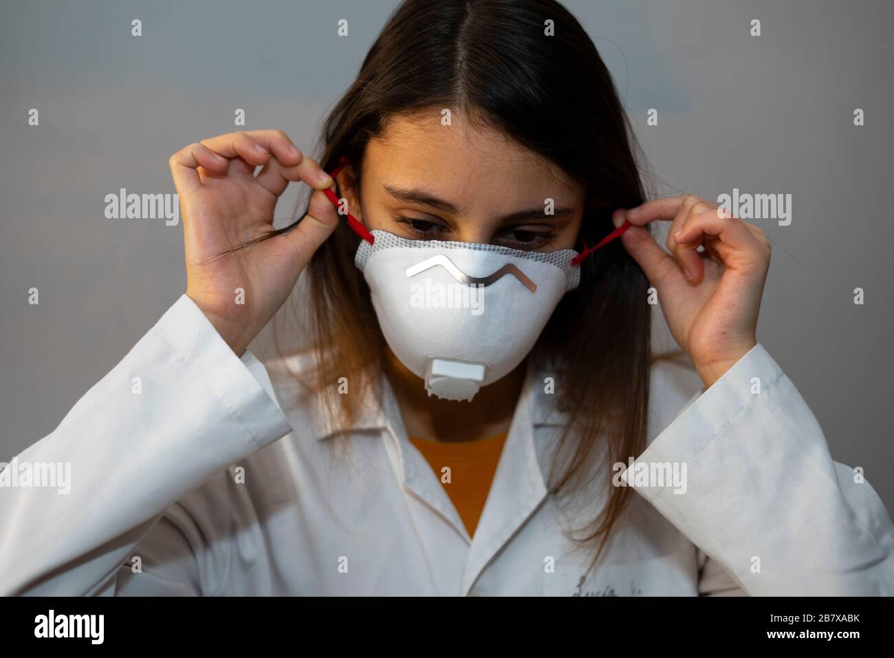 Female doctor putting on a doctor mask. Breathing medical respiratory ...