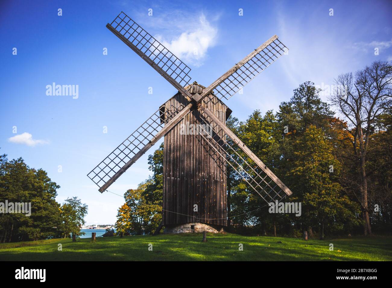 Traditional windmill wooden house on a green grass and under a clear ...