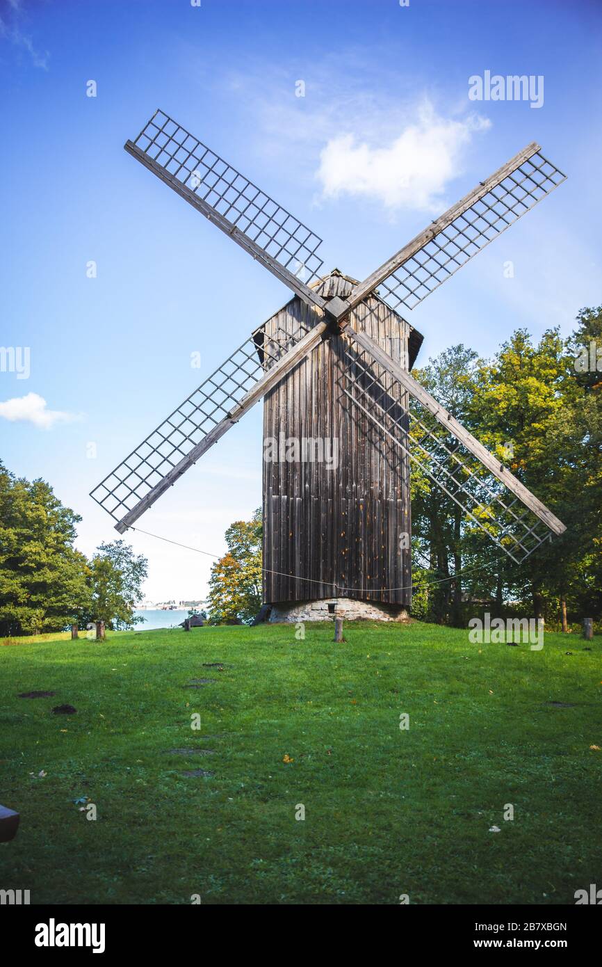 Traditional windmill wooden house on a green grass and under a clear ...