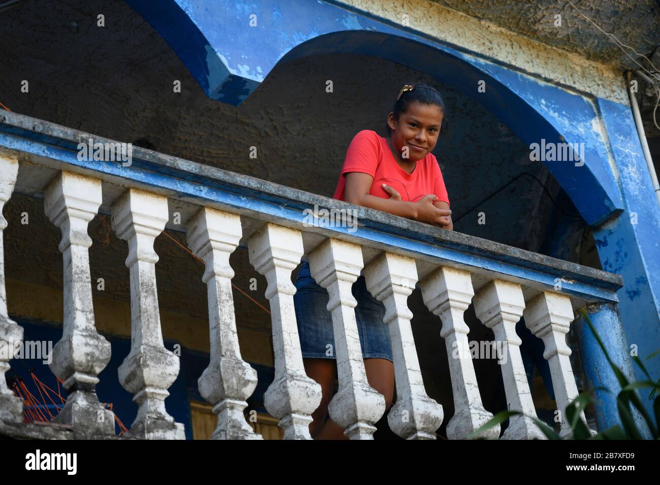 Low angle view of woman looking from balcony, Los Fuertes, Roatan ...