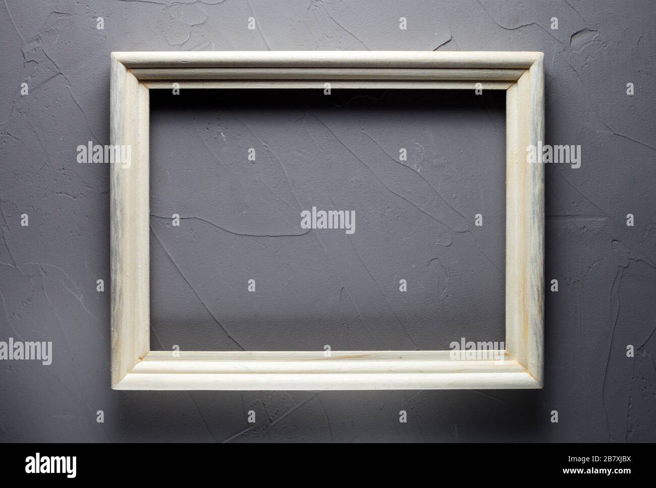 Wooden photo frame on concrete wall Stock Photo - Alamy