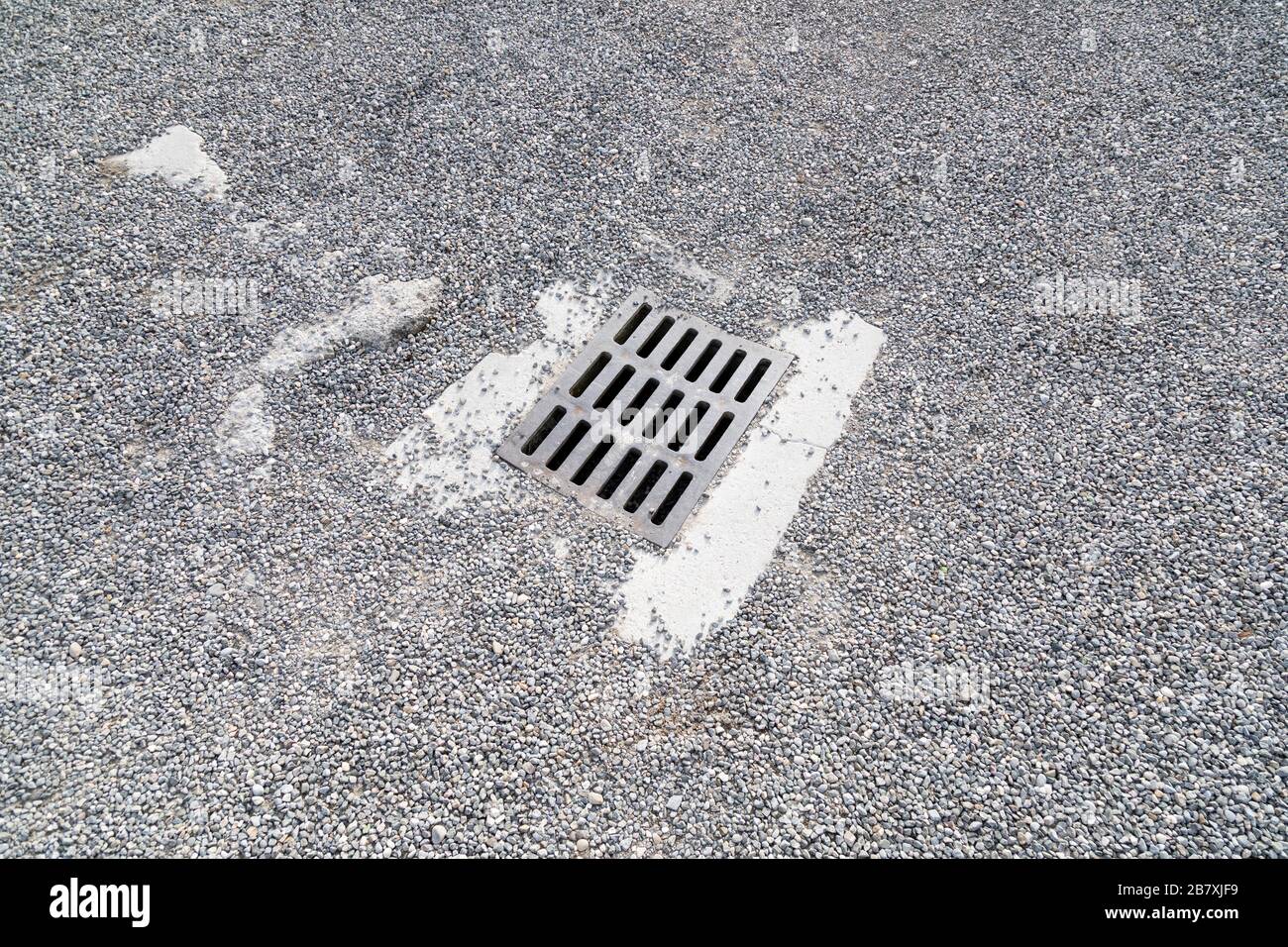 street gully grid on a gravel path with protruding stones Stock Photo ... street gully grid on a gravel path with protruding stones Stock Photo ...