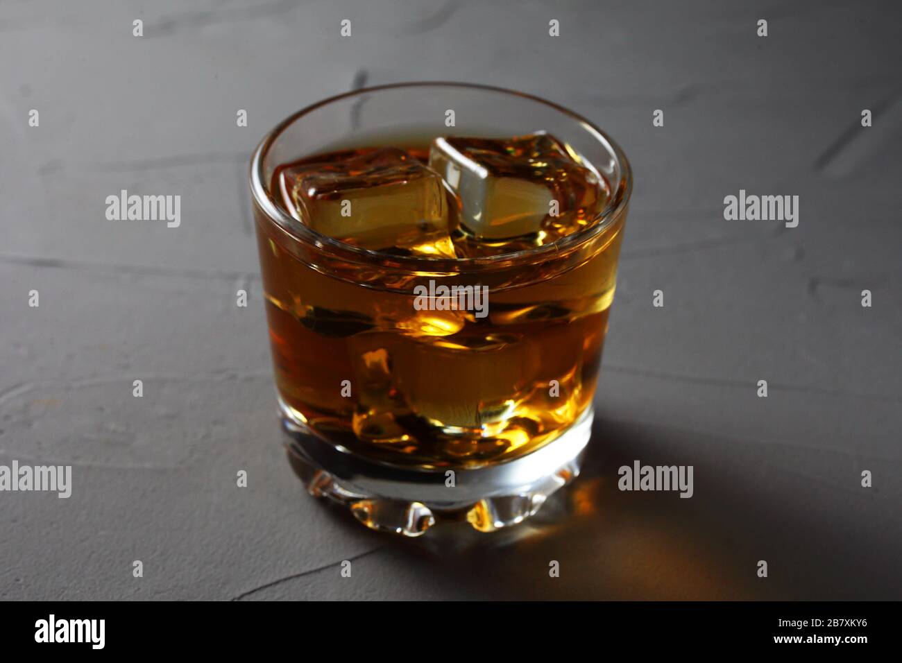 Glass rum glass with ice on a concrete background close-up Stock Photo ...