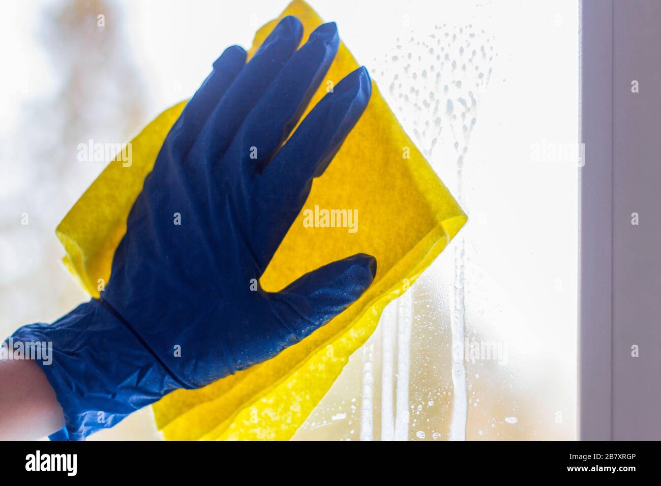 Seasonal cleaning of the house.Women's gloved hands wash the window ...