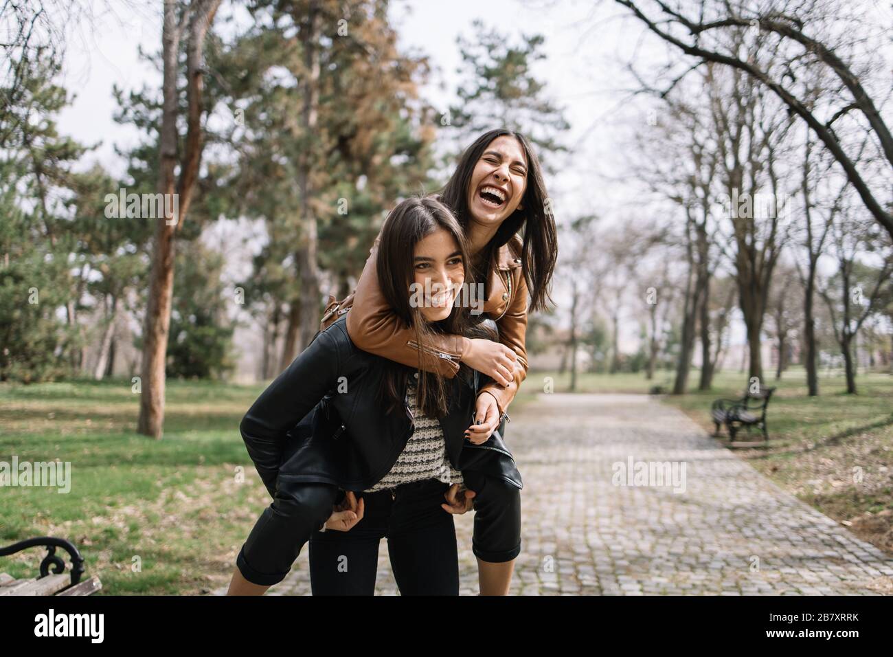 Beautiful woman carrying her female friend on back Stock Photo - Alamy