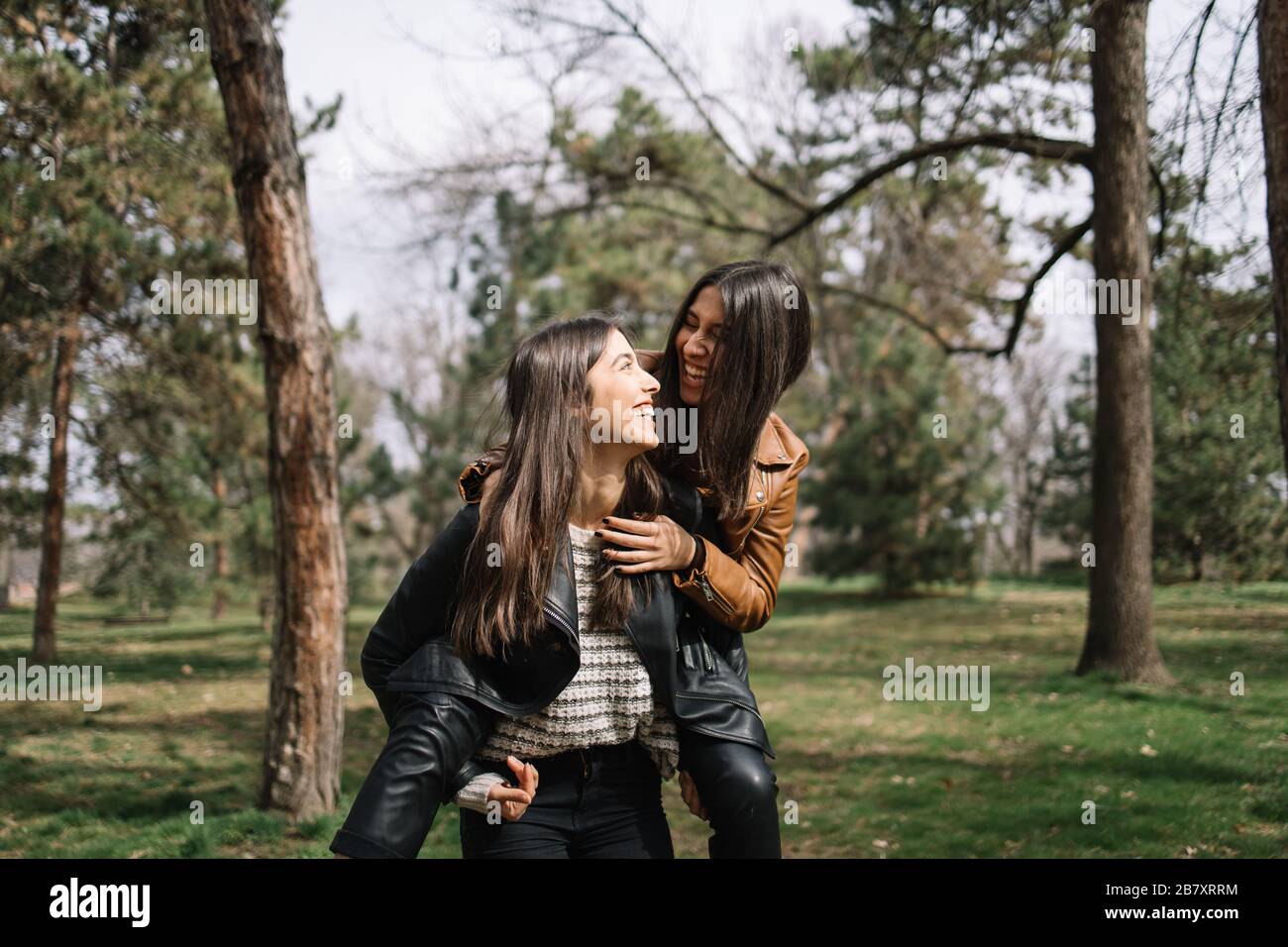 Happy woman carrying her friend on her back Stock Photo - Alamy