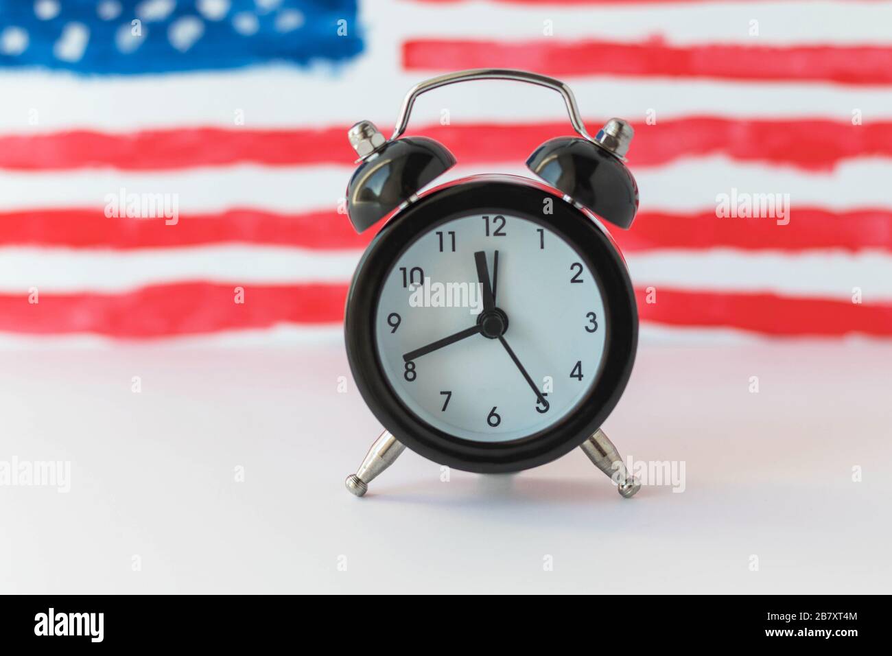 Alarm clock and abstract hand drawn American flag on background ...