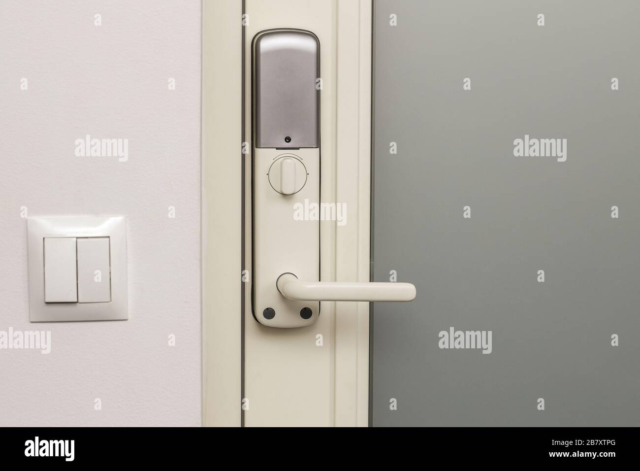 Close up view of an electric combination lock on a white door. Interior ...