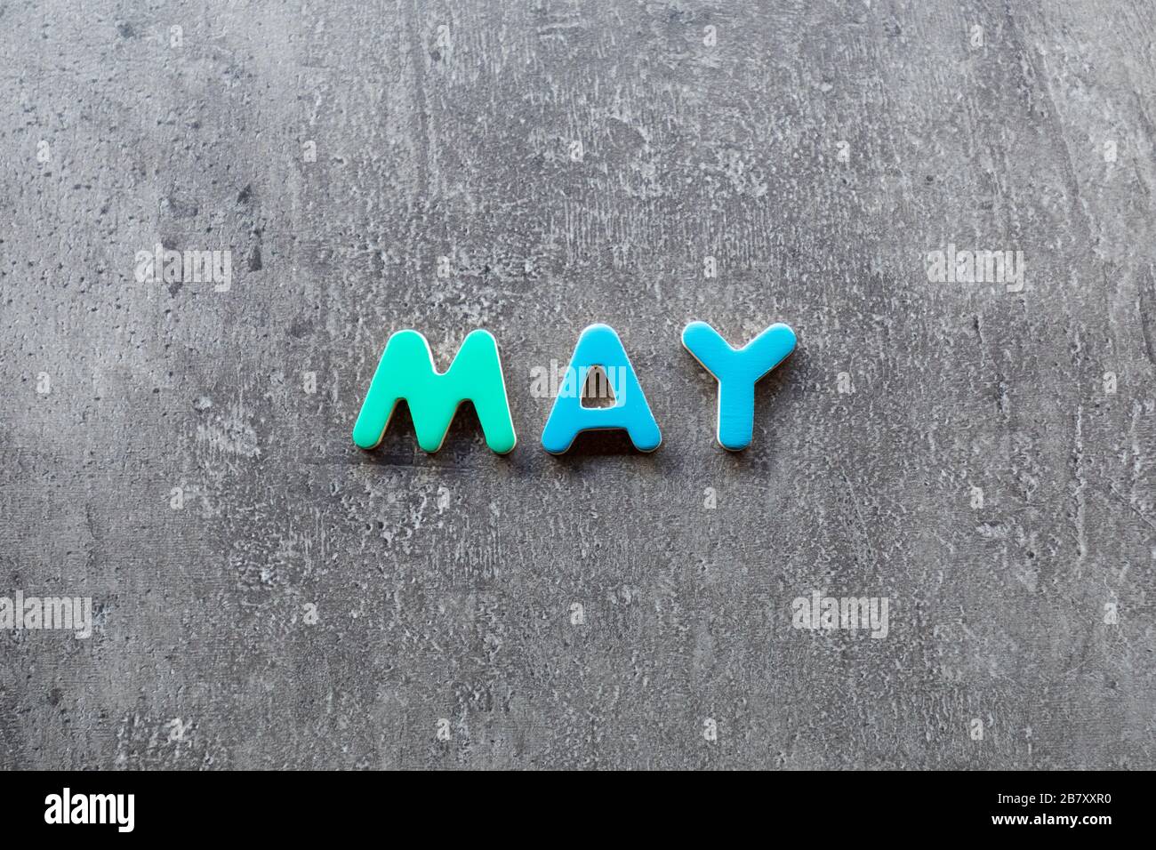 May word written with colorful letters on grey granite stone background ...