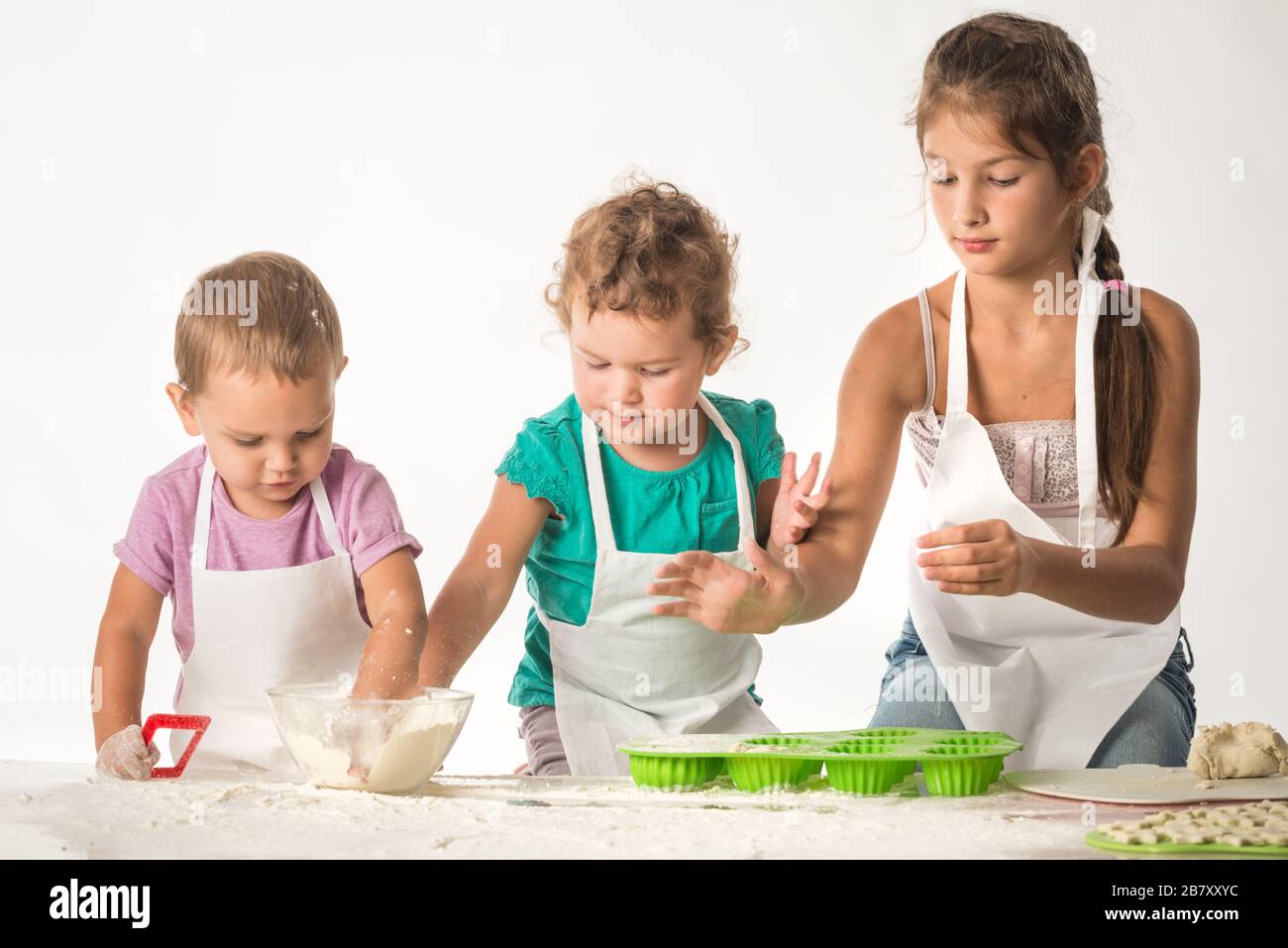 Cute little kids in a cook's suit while about to cook pastries on a ...