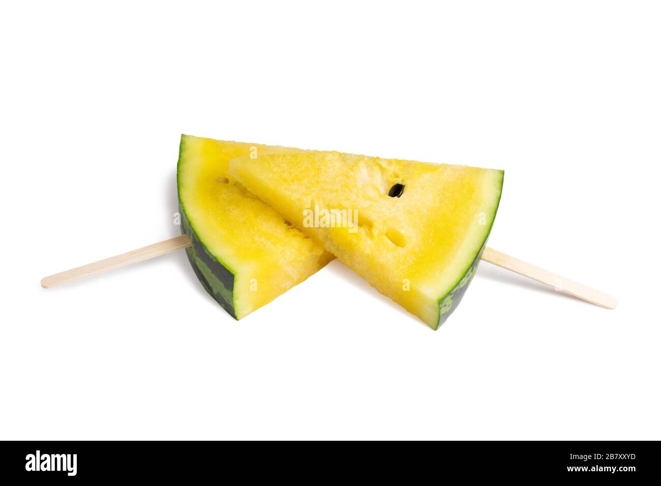 Triangular slices of yellow watermelon on wooden sticks isolated on a ...