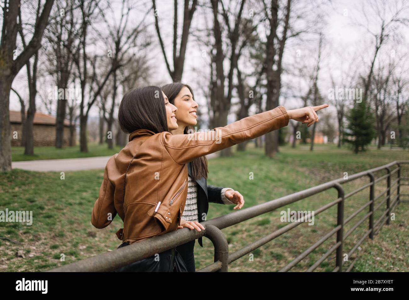 Two girls in zoo pointing with hand Stock Photo - Alamy