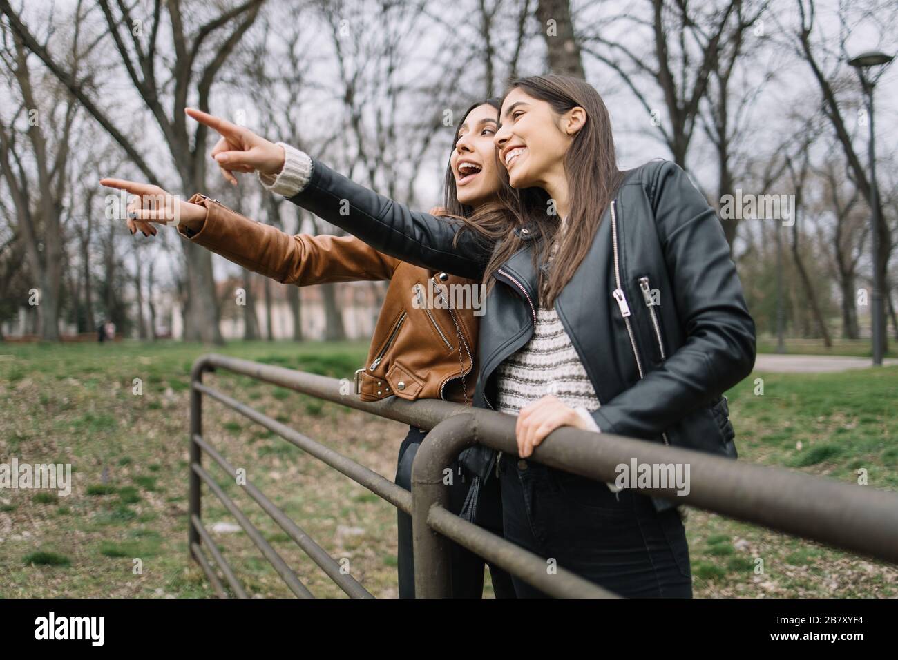 Girls pointing with finger far away in the park Stock Photo - Alamy