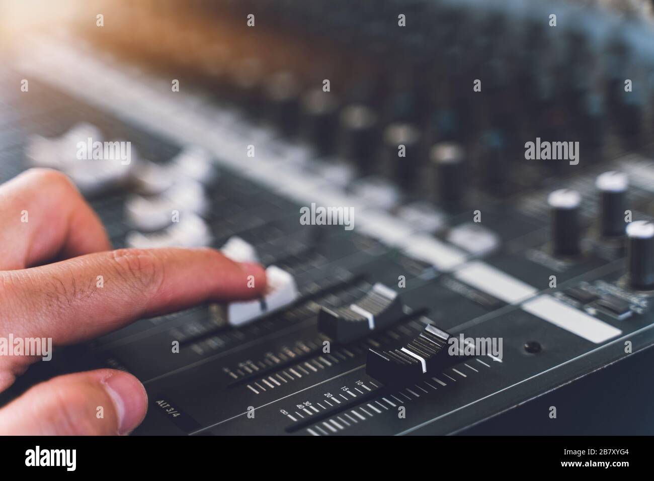 Professional audio mixing console with faders and adjusting knobs ...