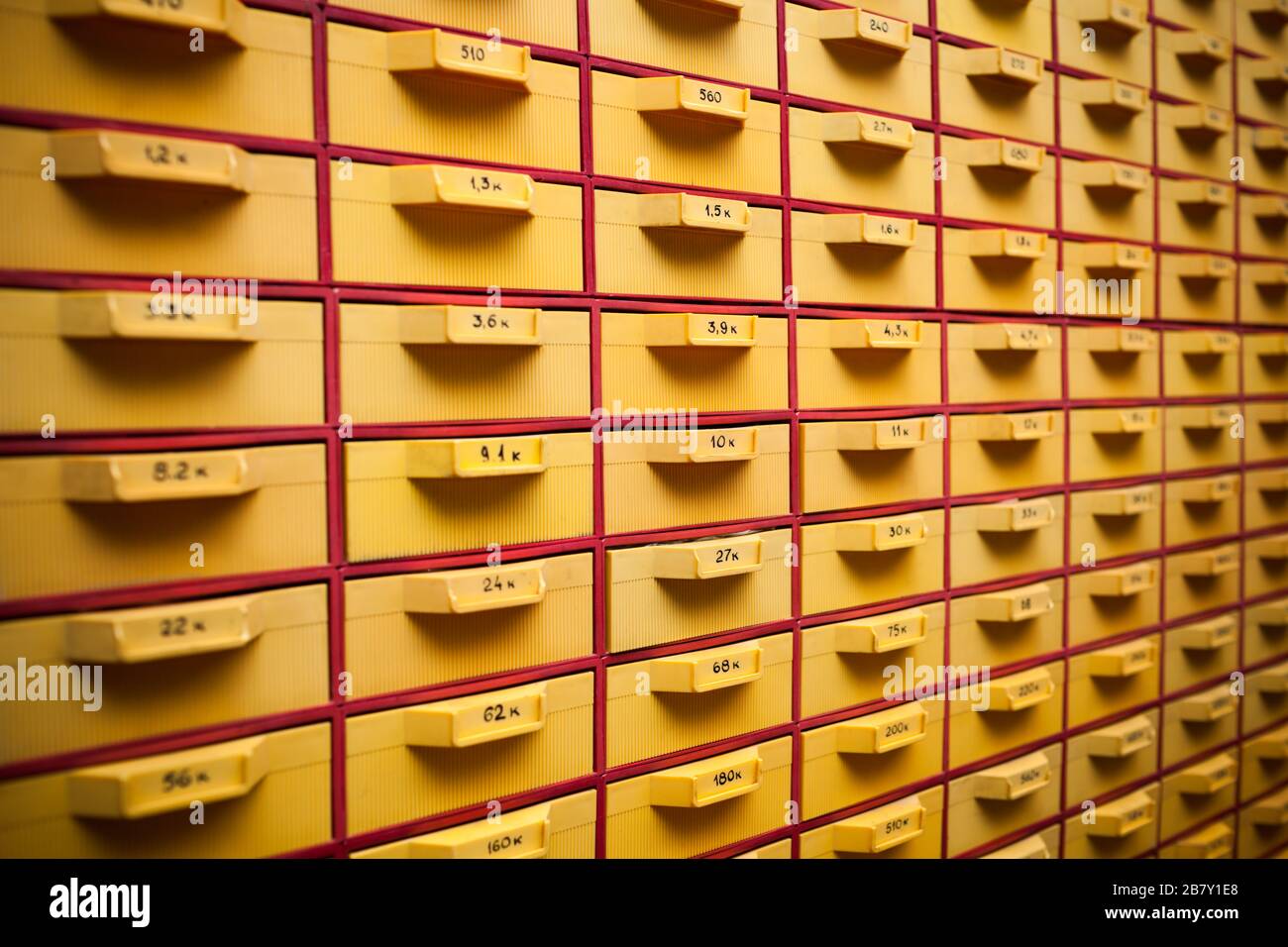 Security guard a large yellow cabinet with cells and numbers for ...