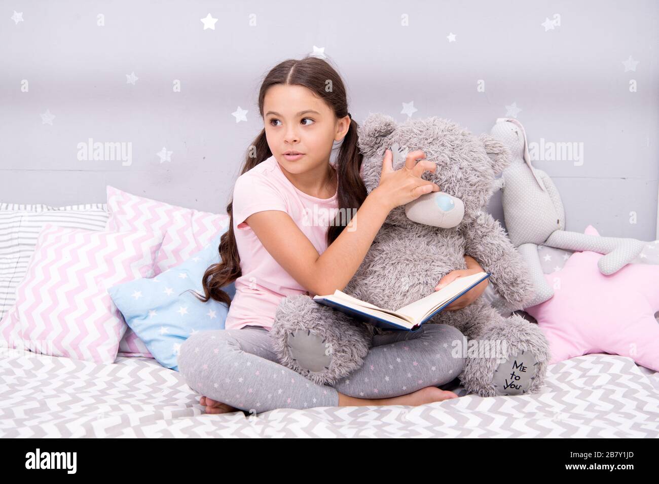 Home reading. Cute literature reader in bedroom. Little child read book ...
