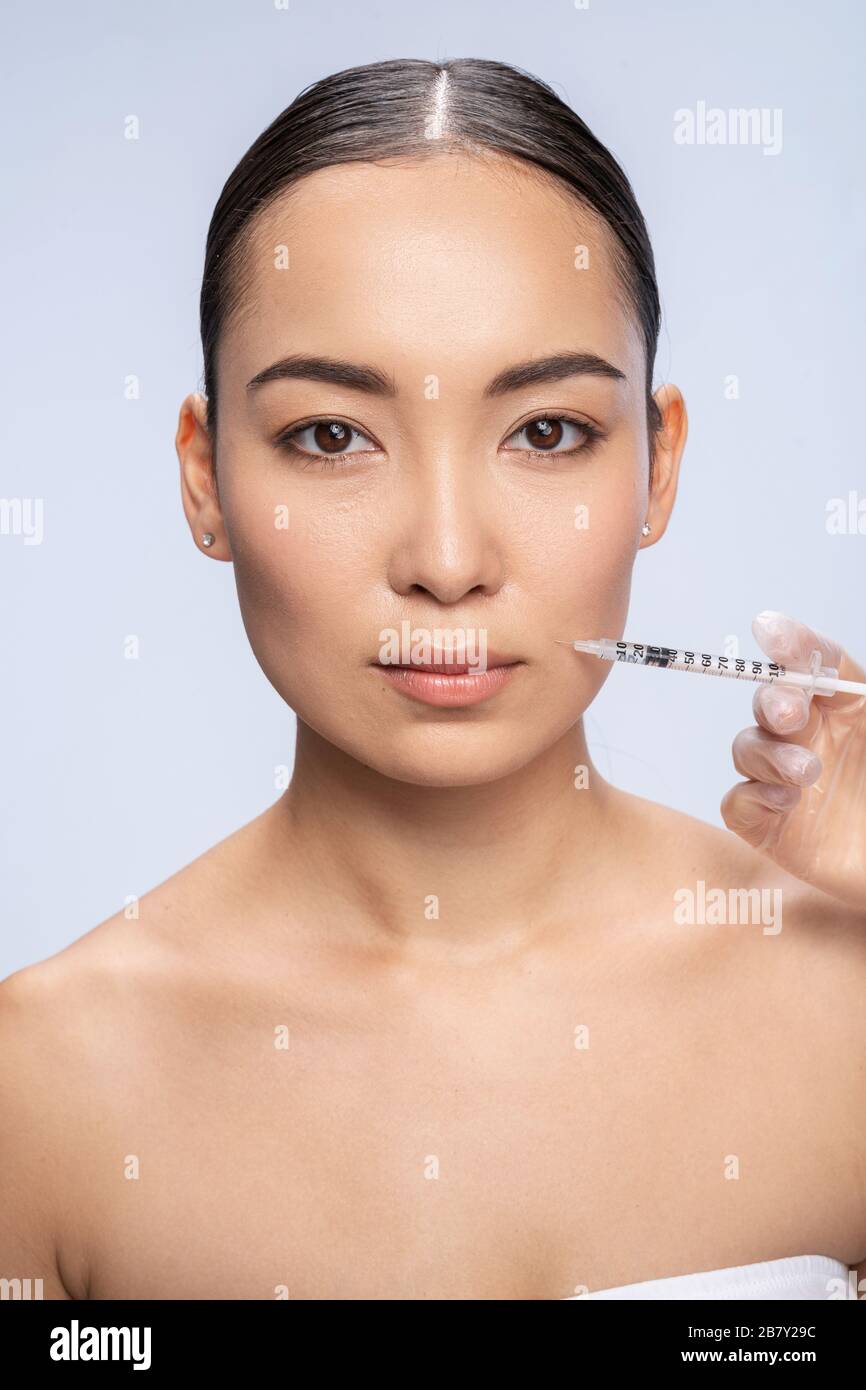 Asian pretty woman is getting an injection Stock Photo - Alamy