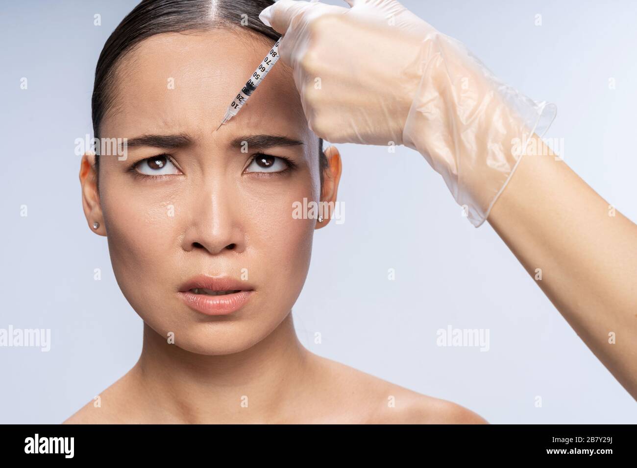 Pretty young lady is receiving injection head-on Stock Photo - Alamy
