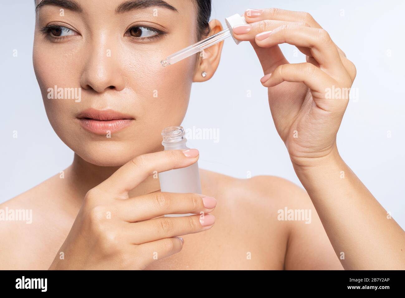 Woman applying facial serum using hi-res stock photography and images ...