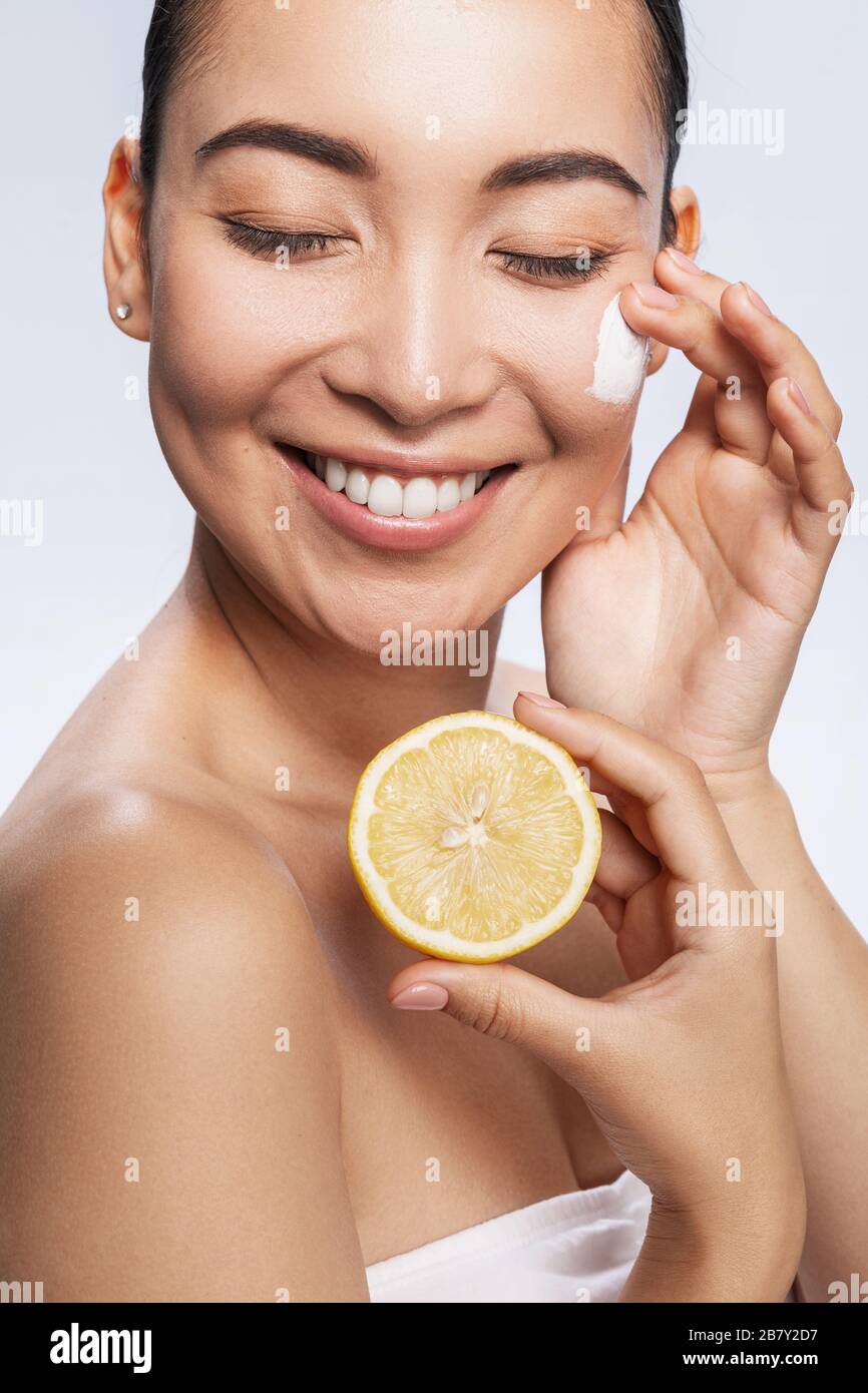 Smiling pretty lady posing with lotion and lemon Stock Photo - Alamy