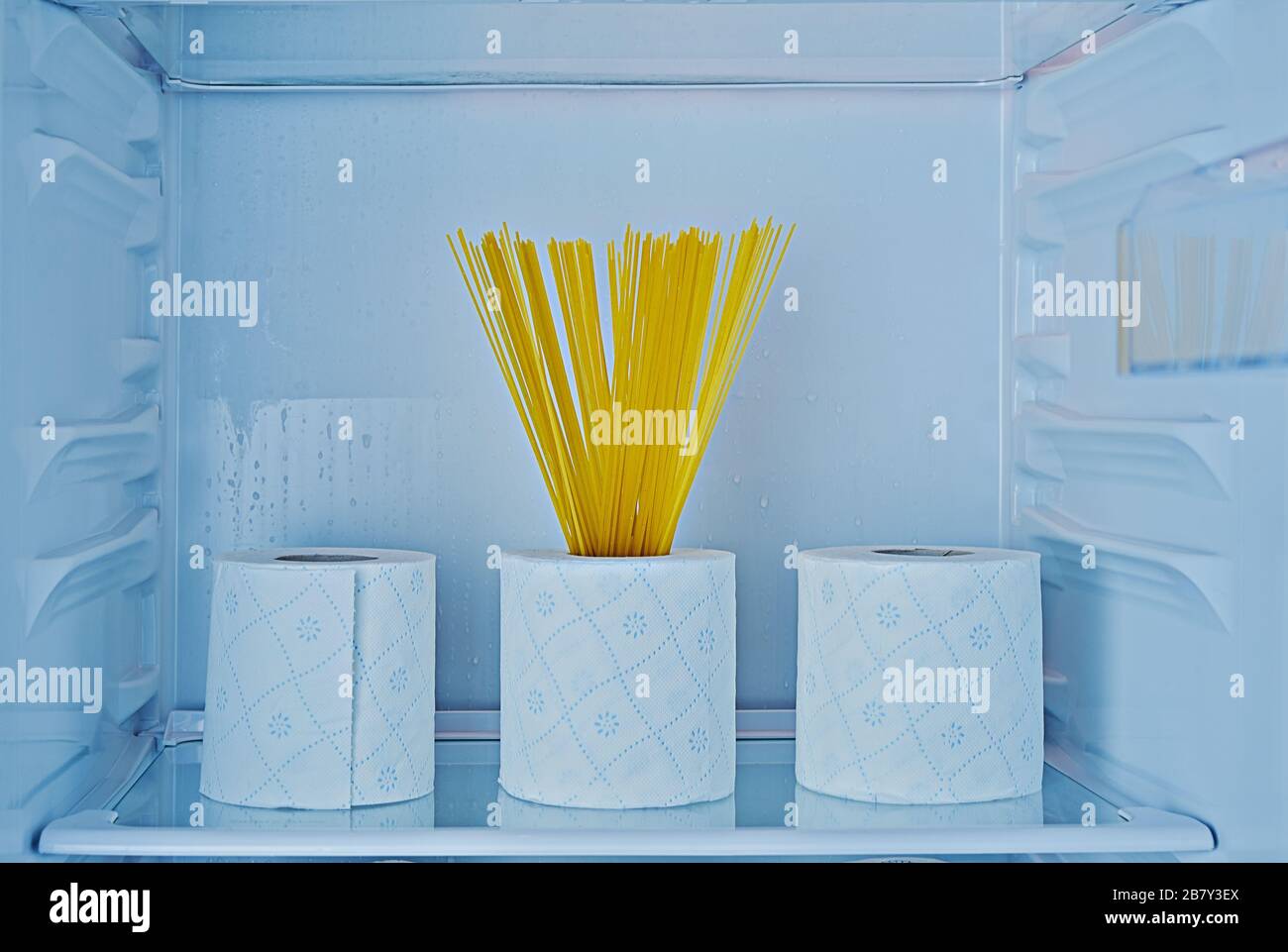 Rolls of toilet paper and spaghetti on shelves in fridge as symbol of ...