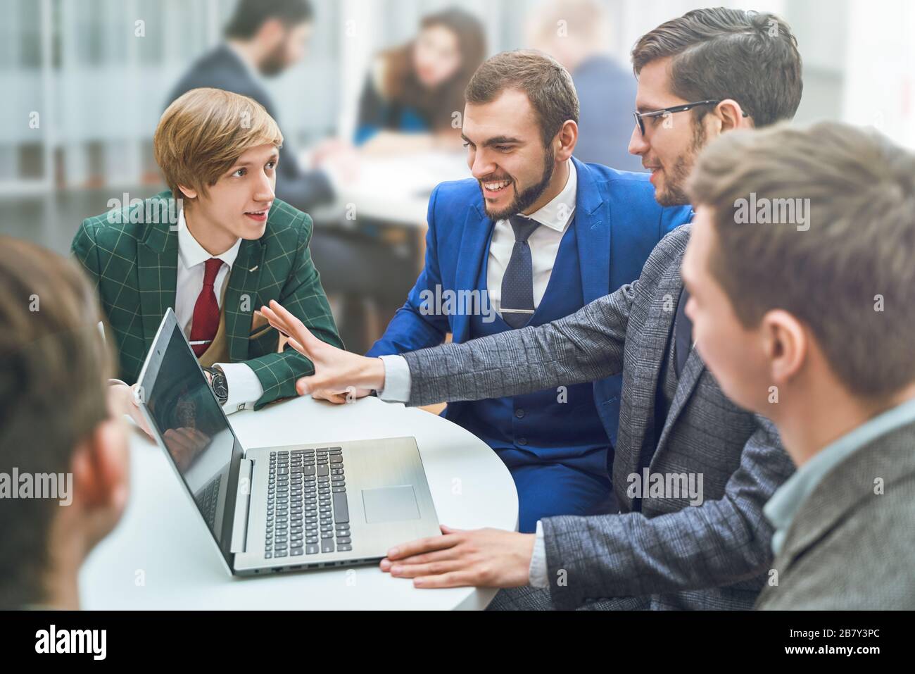 Group of young business people working and communicating while sitting ...