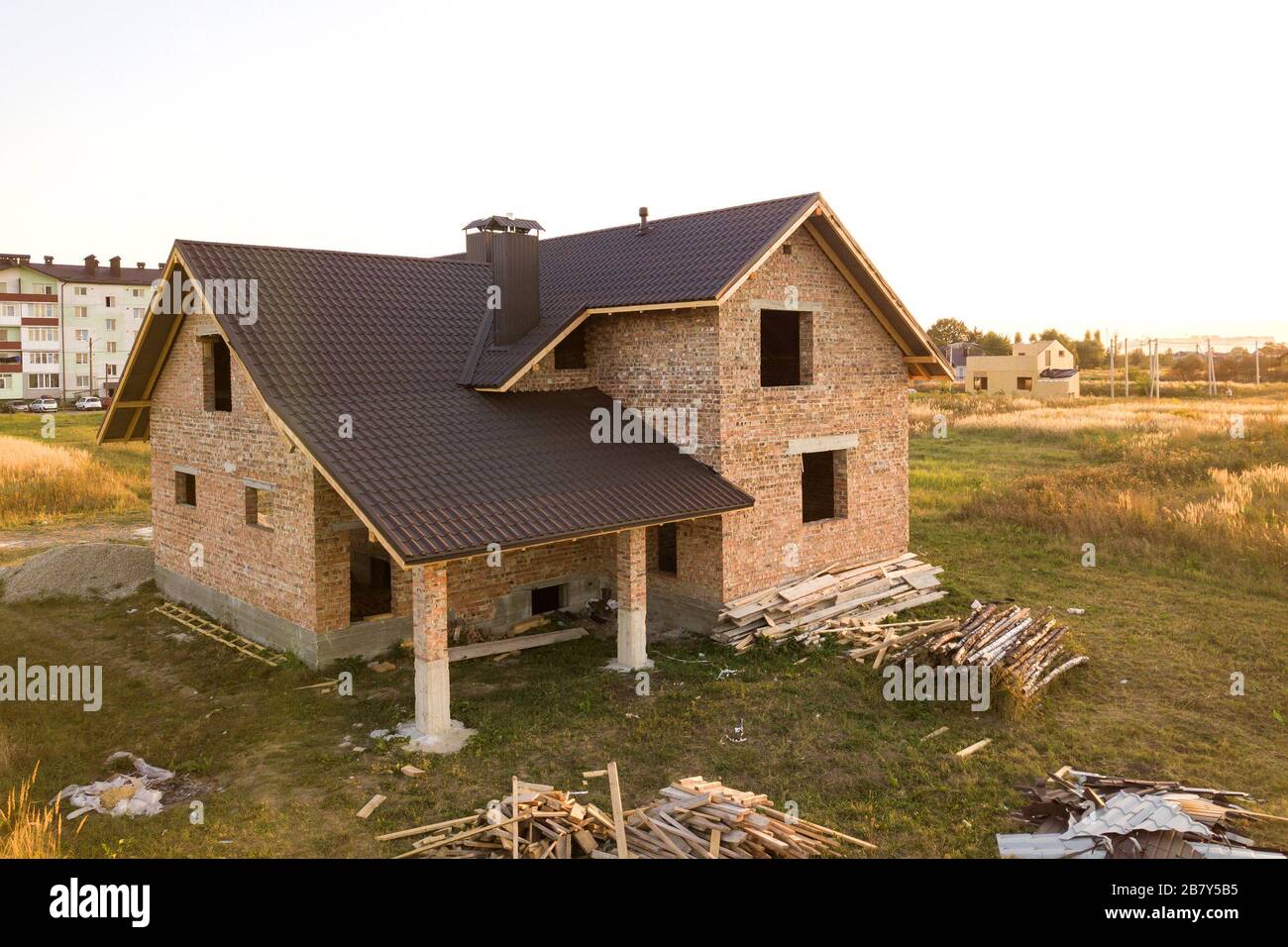 Unfinished brick house with wooden roof structure covered with metal ...