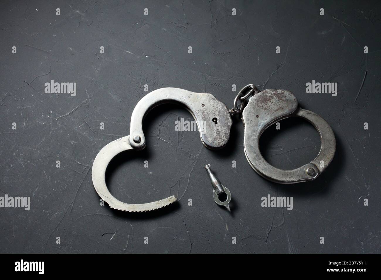 police handcuffs on a dark background Stock Photo - Alamy