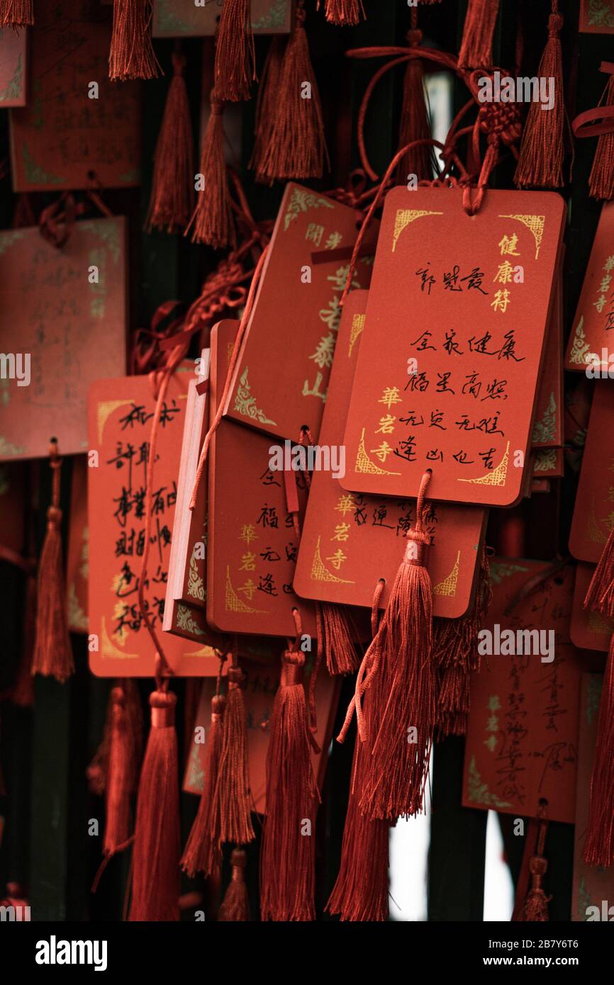 Red praying wish cards hang on traditional stand written in Chinese ...