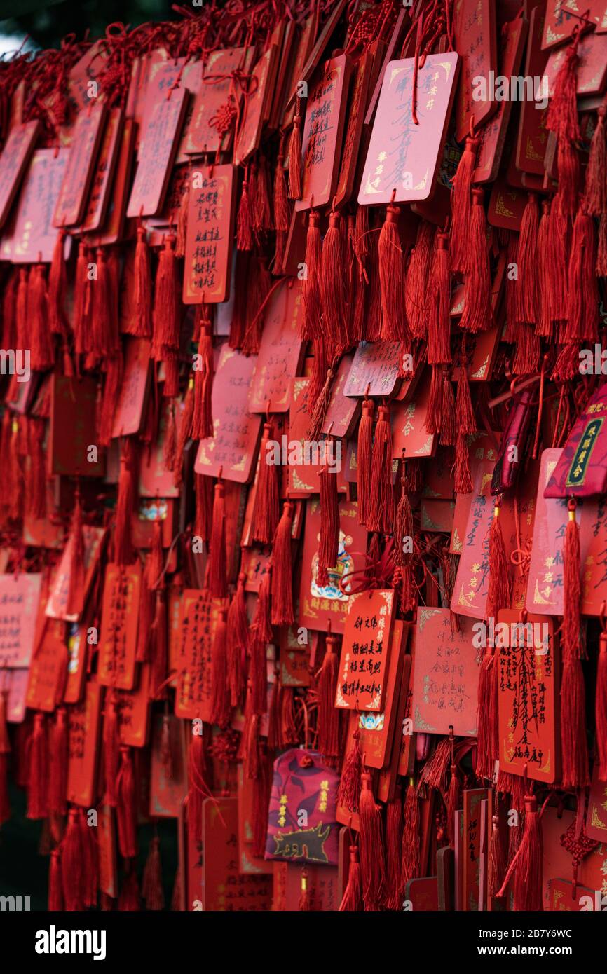 Red praying wish cards hang on traditional stand written in Chinese ...
