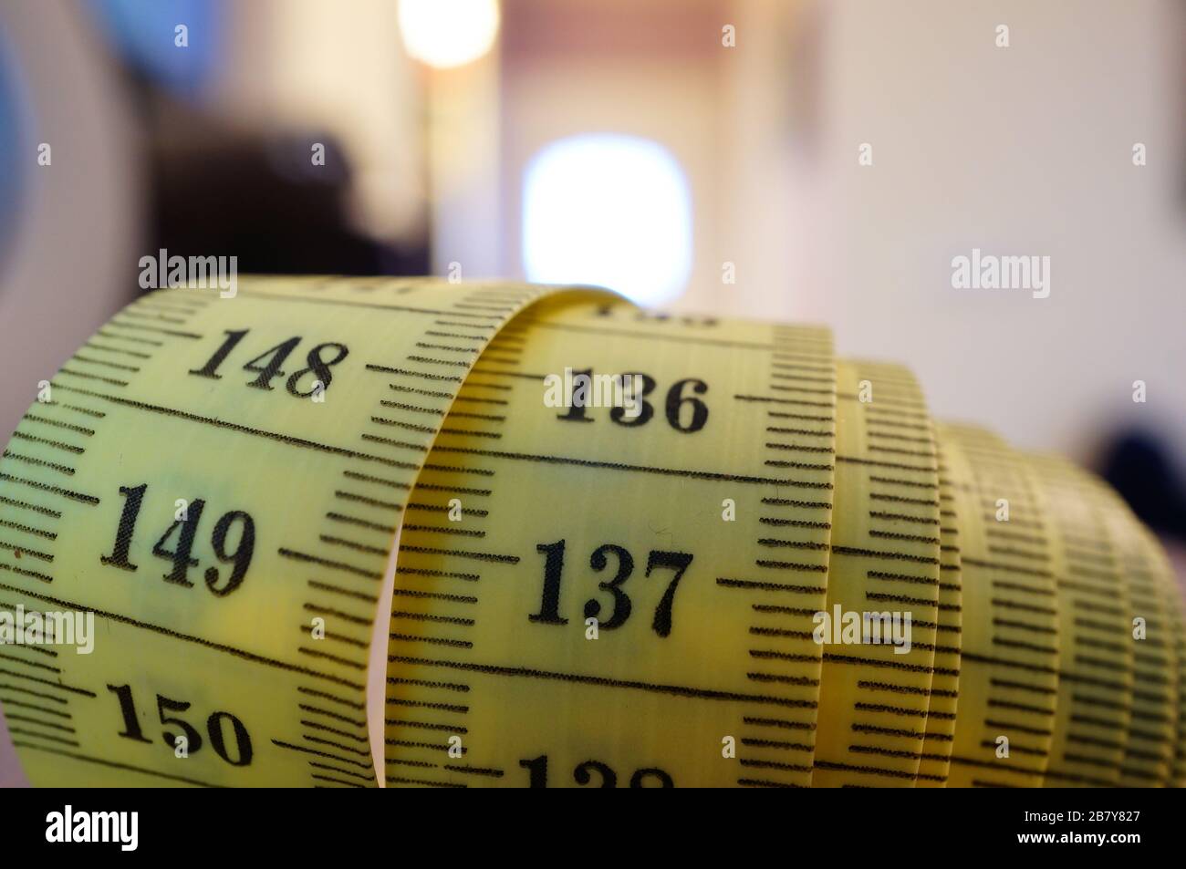 Yellow measuring tape rolled into a circular form Stock Photo - Alamy