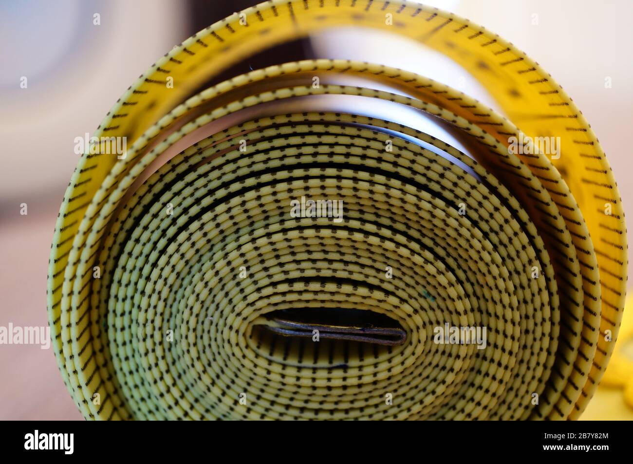 Yellow measuring tape rolled into a circular form Stock Photo - Alamy