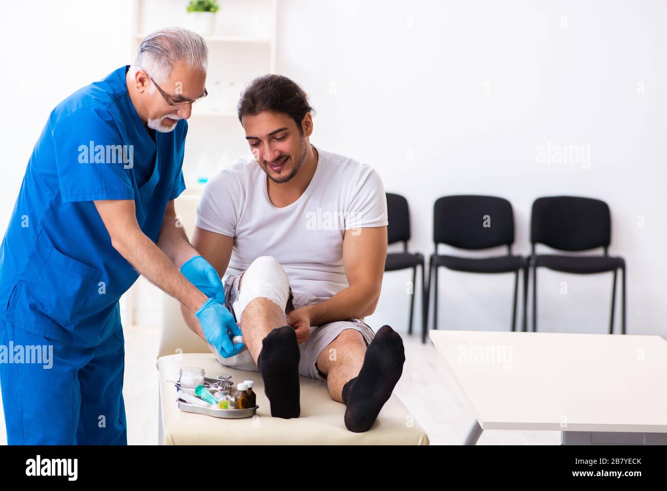 Leg injured man visiting doctor in first aid concept Stock Photo - Alamy