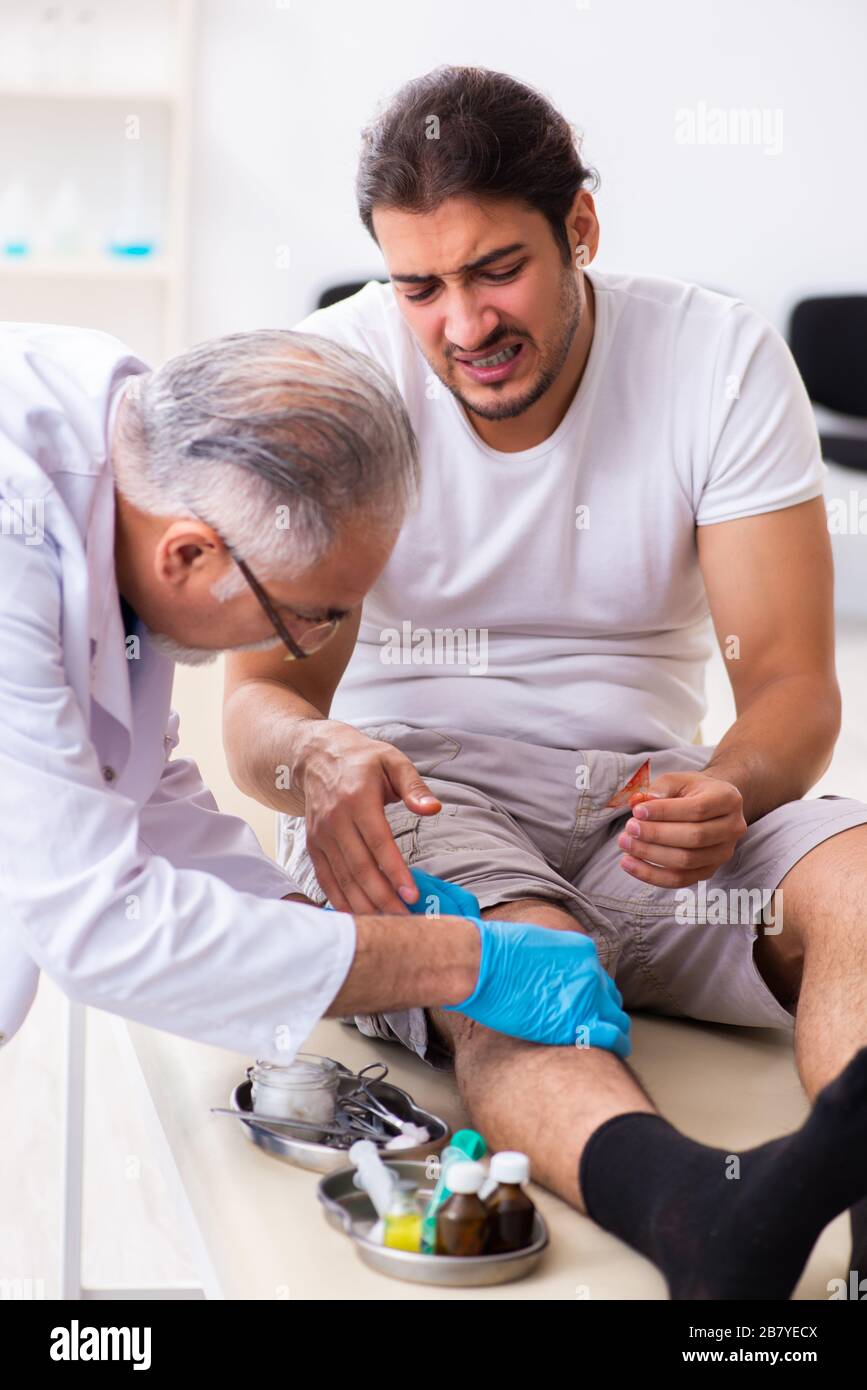 Leg injured man visiting doctor in first aid concept Stock Photo - Alamy