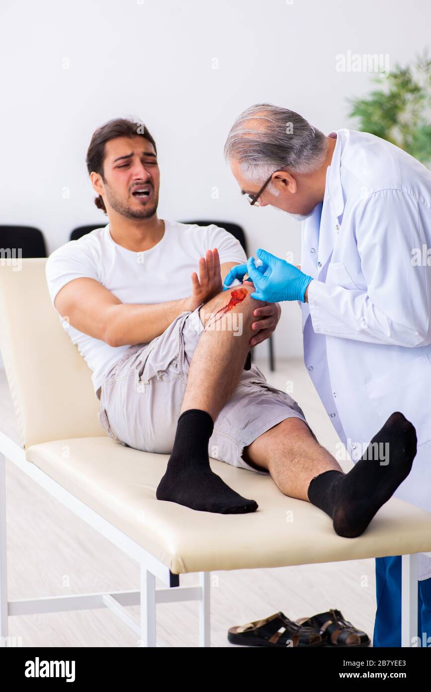 Leg injured man visiting doctor in first aid concept Stock Photo - Alamy