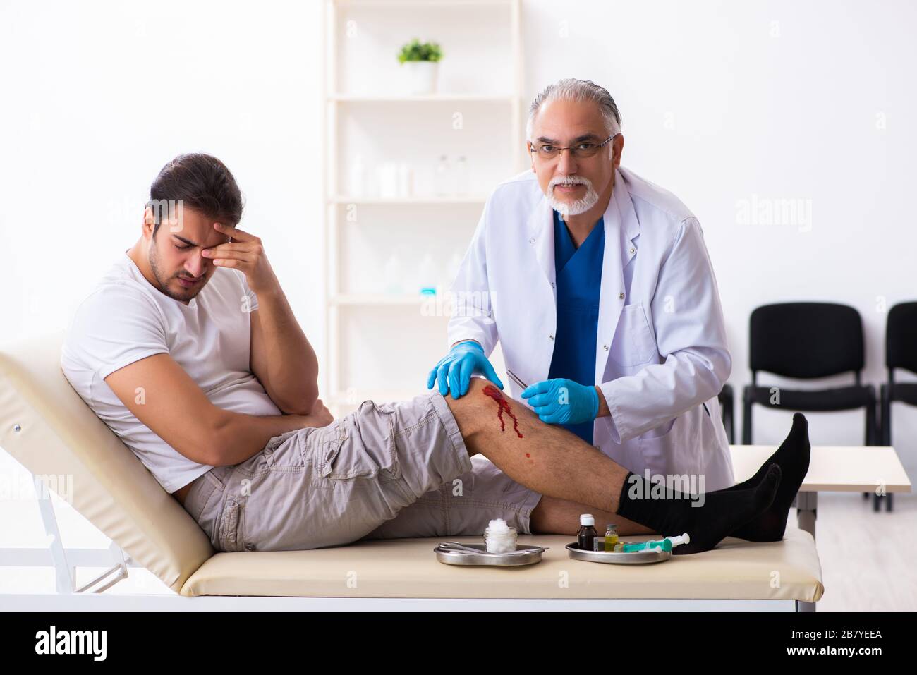 Leg injured man visiting doctor in first aid concept Stock Photo - Alamy