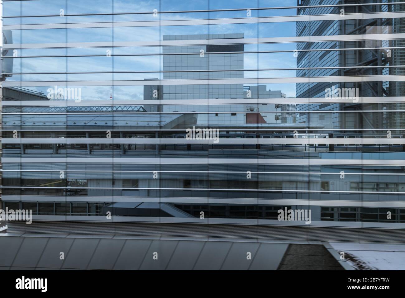 monorail station and building reflected in windows of modern new facade ...