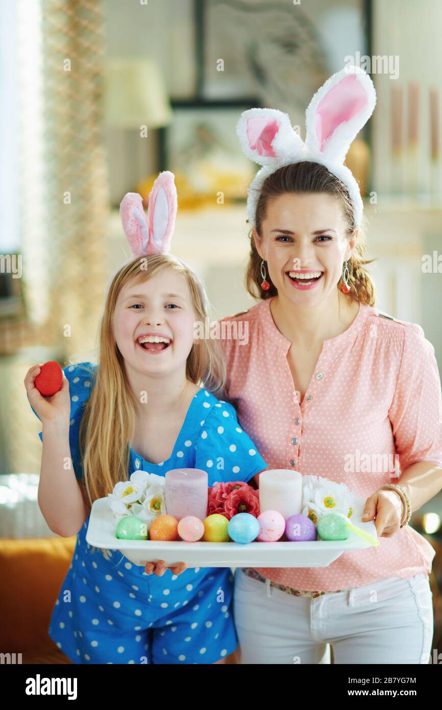 smiling elegant mother and daughter in easter bunny ears showing easter ...
