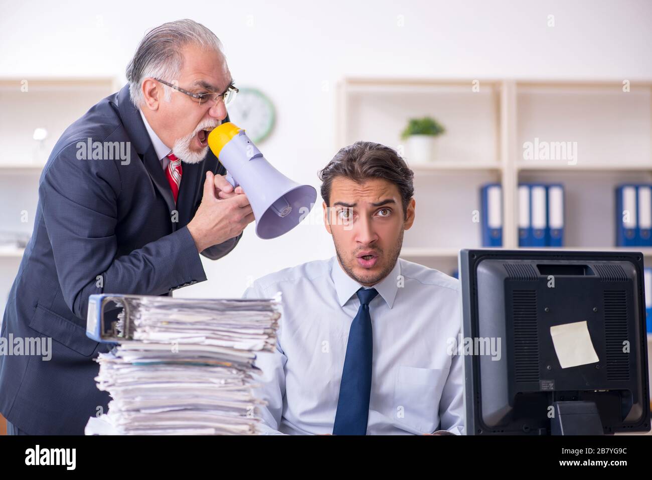 Old boss and young employee in the office Stock Photo - Alamy